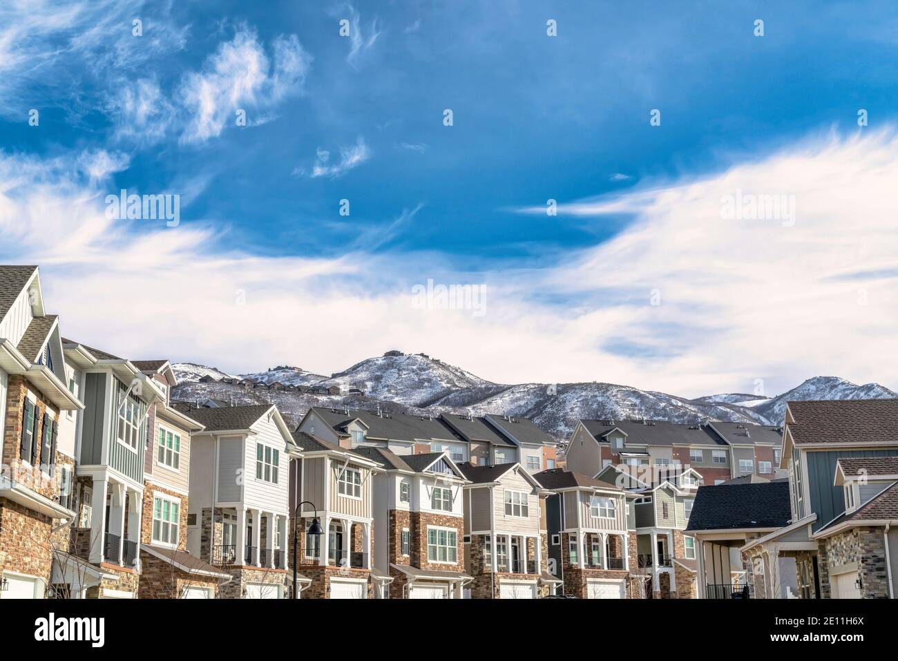 Beautiful houses in Utah Valley against snowy mountain peak and cloudy ...
