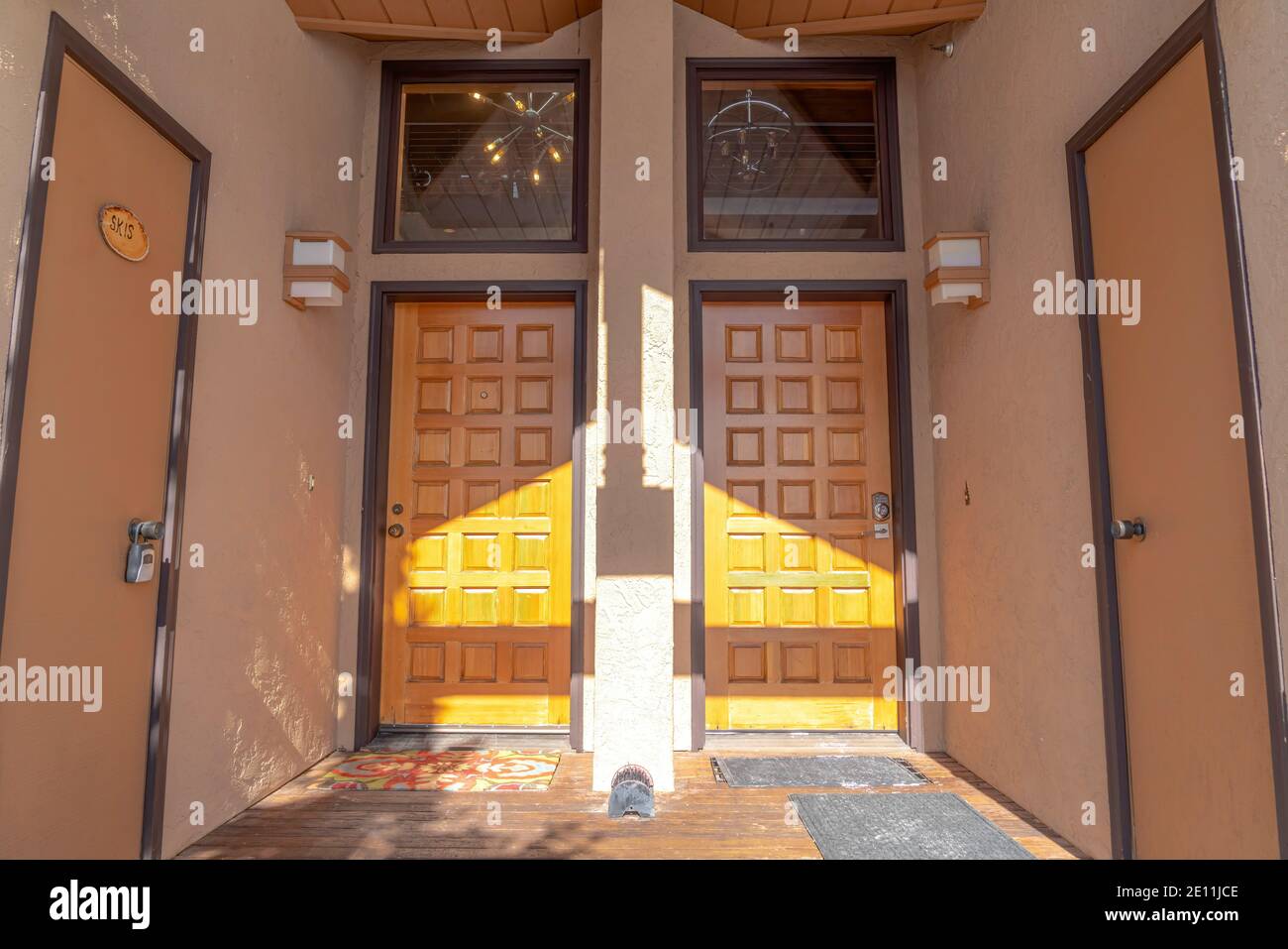Flush and panel doors with transom windows at the facade of residential ...