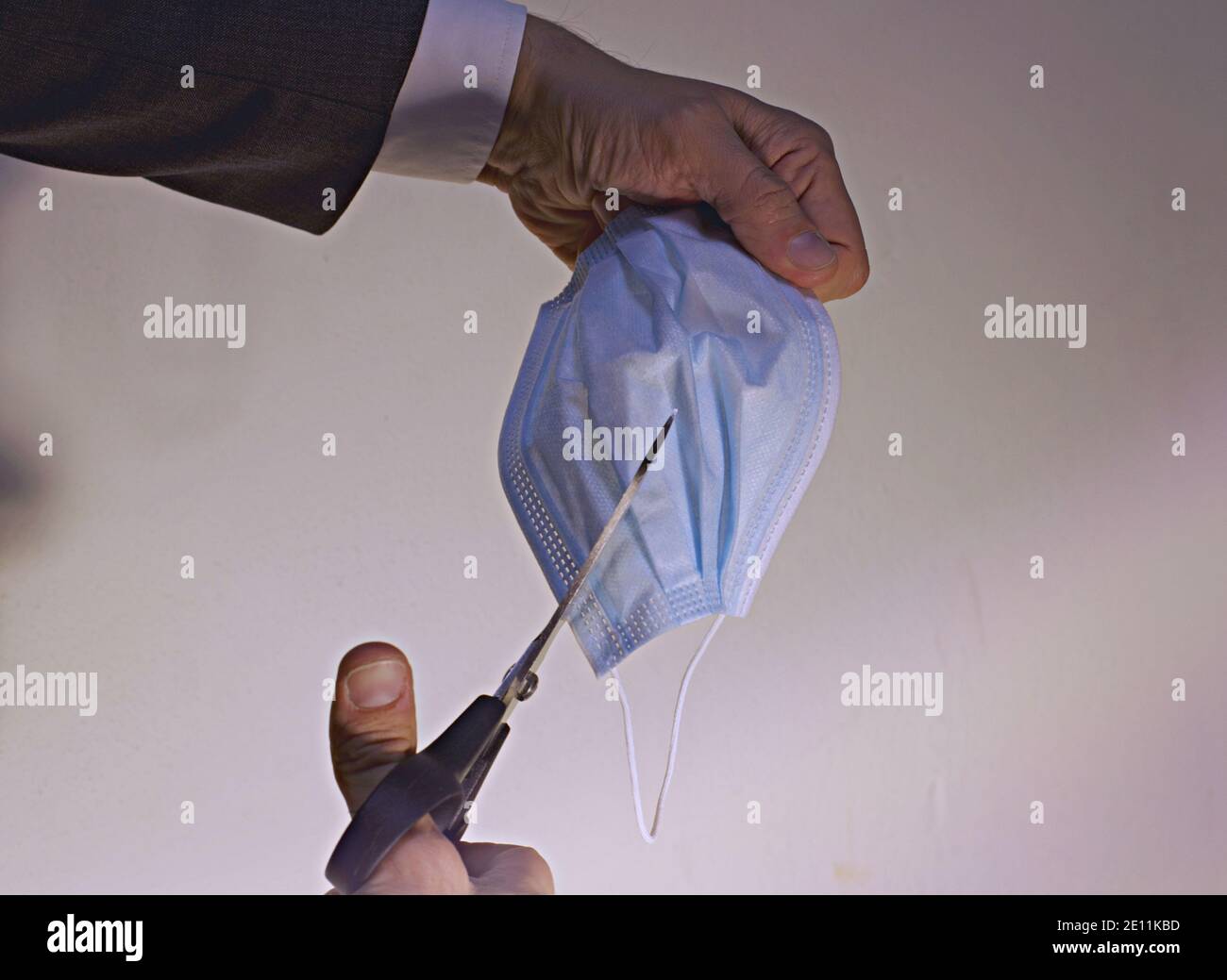 person cutting a surgical mask , concept of conspiracy theory Corona ...