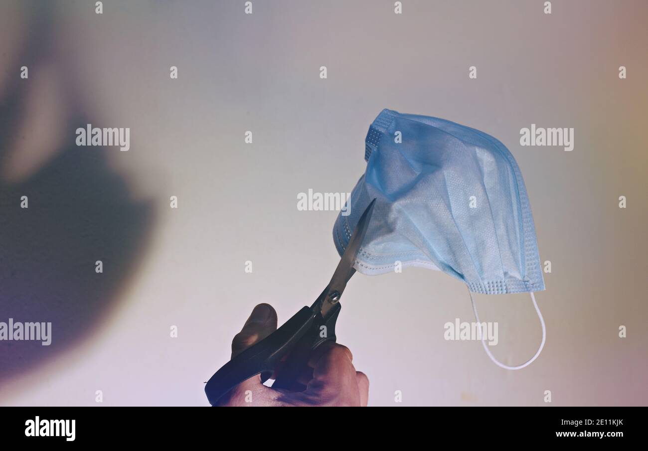 person cutting a surgical mask , concept of conspiracy theory Corona ...