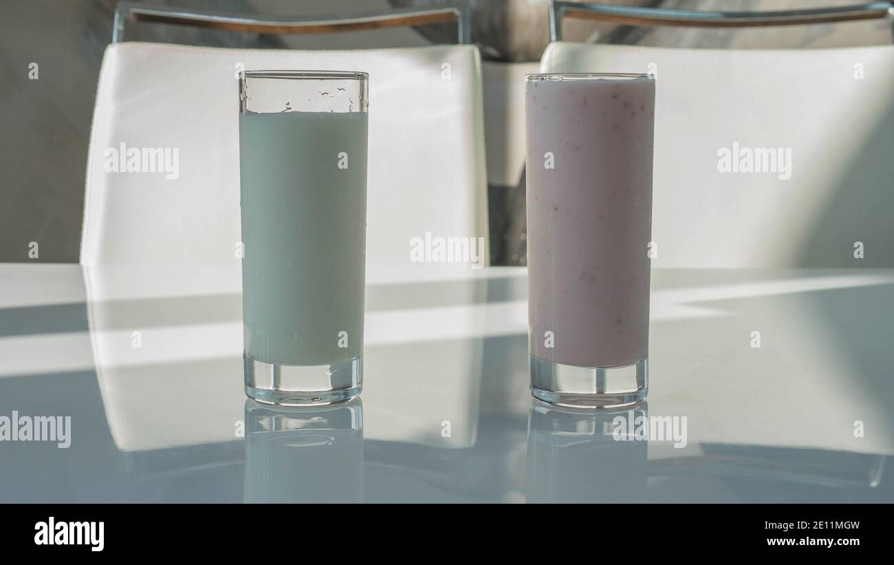Yogurt in a glass on a white kitchen table, milk drinks in glasses ...