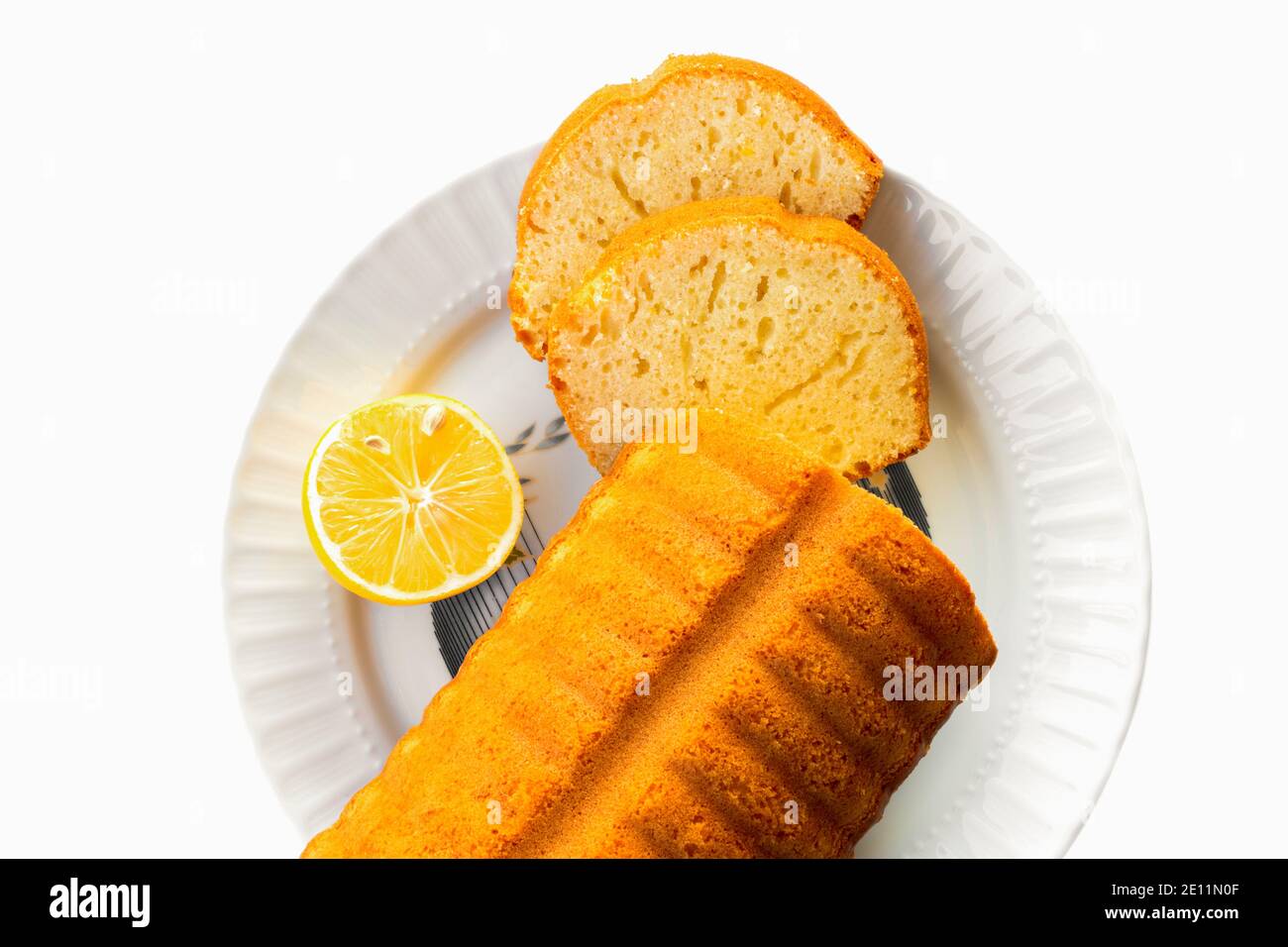Sliced lemon cake and half-cut lemon on the plate on the white ...