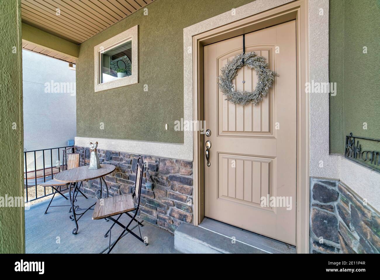 Vintage table and chairs at the open porch of house with wreath on ...