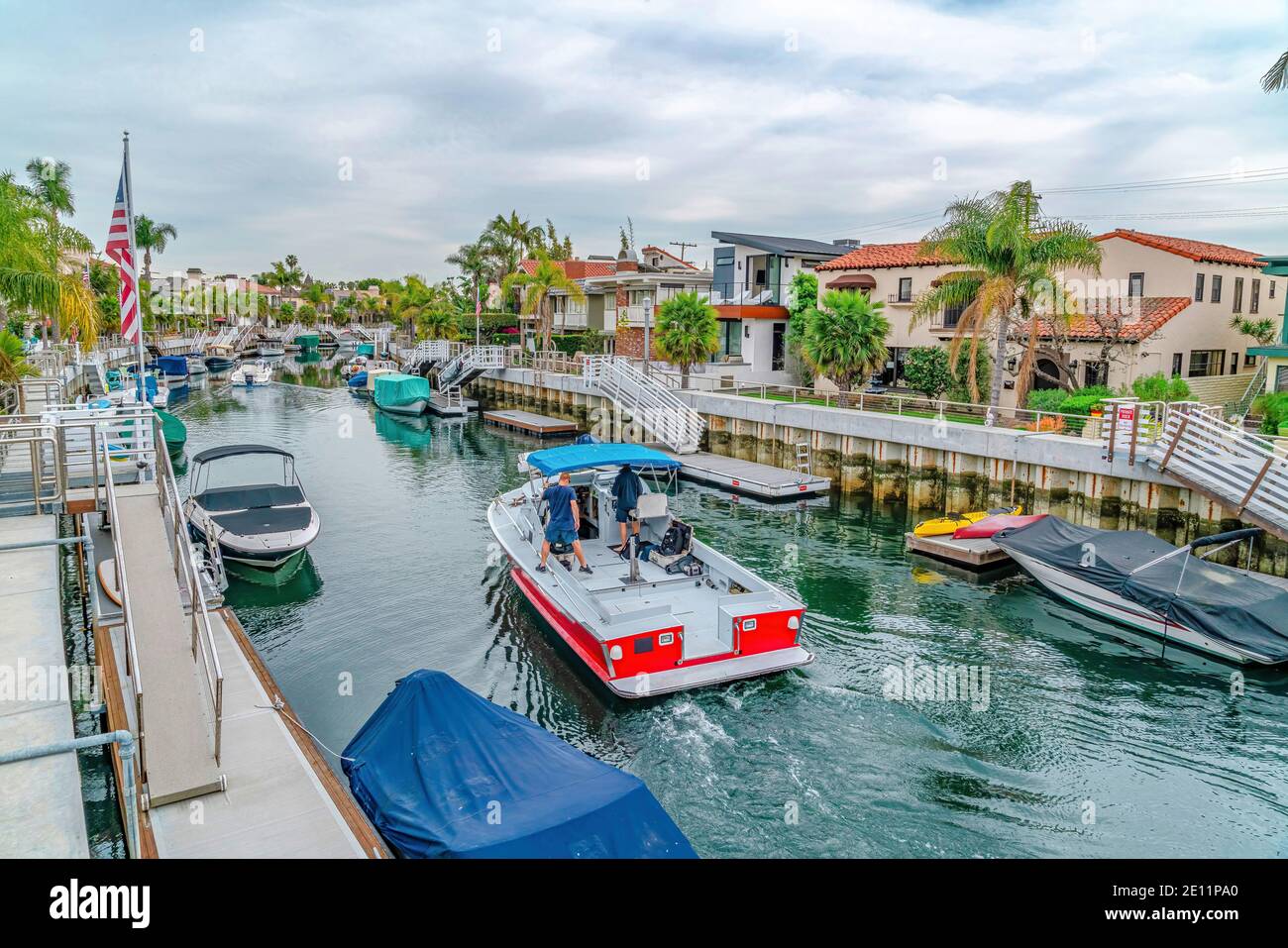 Boats at a canal lined with walkways and palm trees in Long Beach ...