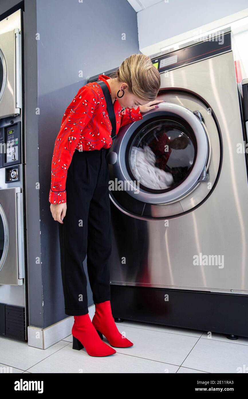 Young white woman sitting with washing machine Stock Photo - Alamy