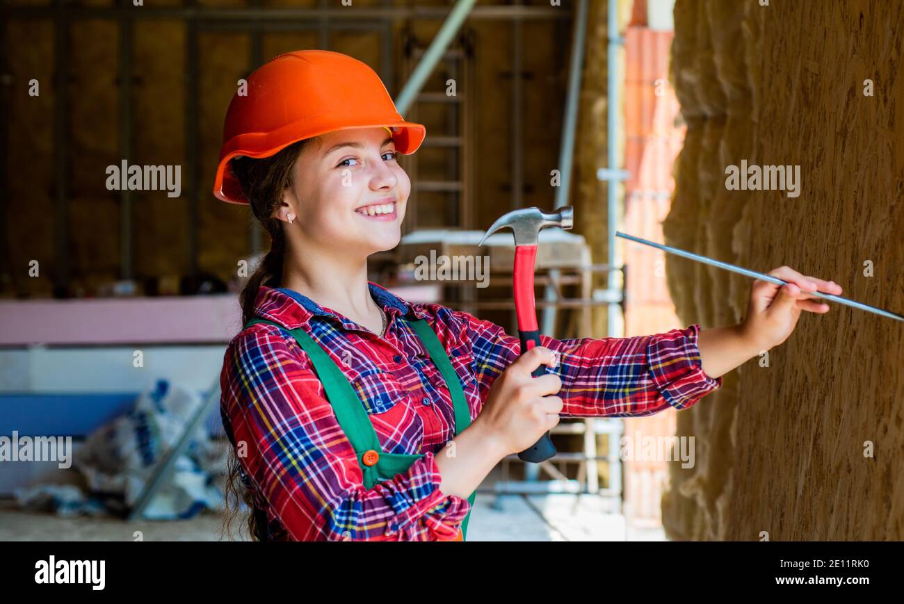 cheerful child laborer using building uniform and hammer tool, labor ...
