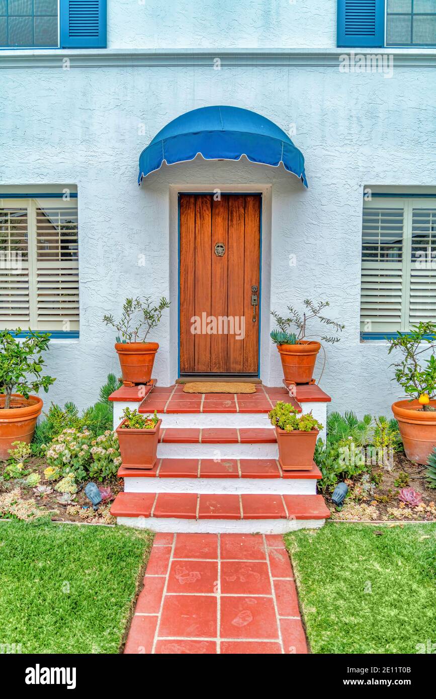 Home with red paved pathway and steps leading to brown wooden front ...