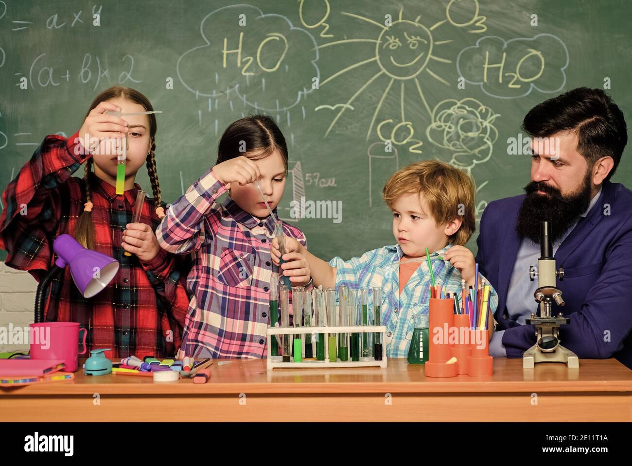 School club education. Teacher and pupils test tubes in classroom ...