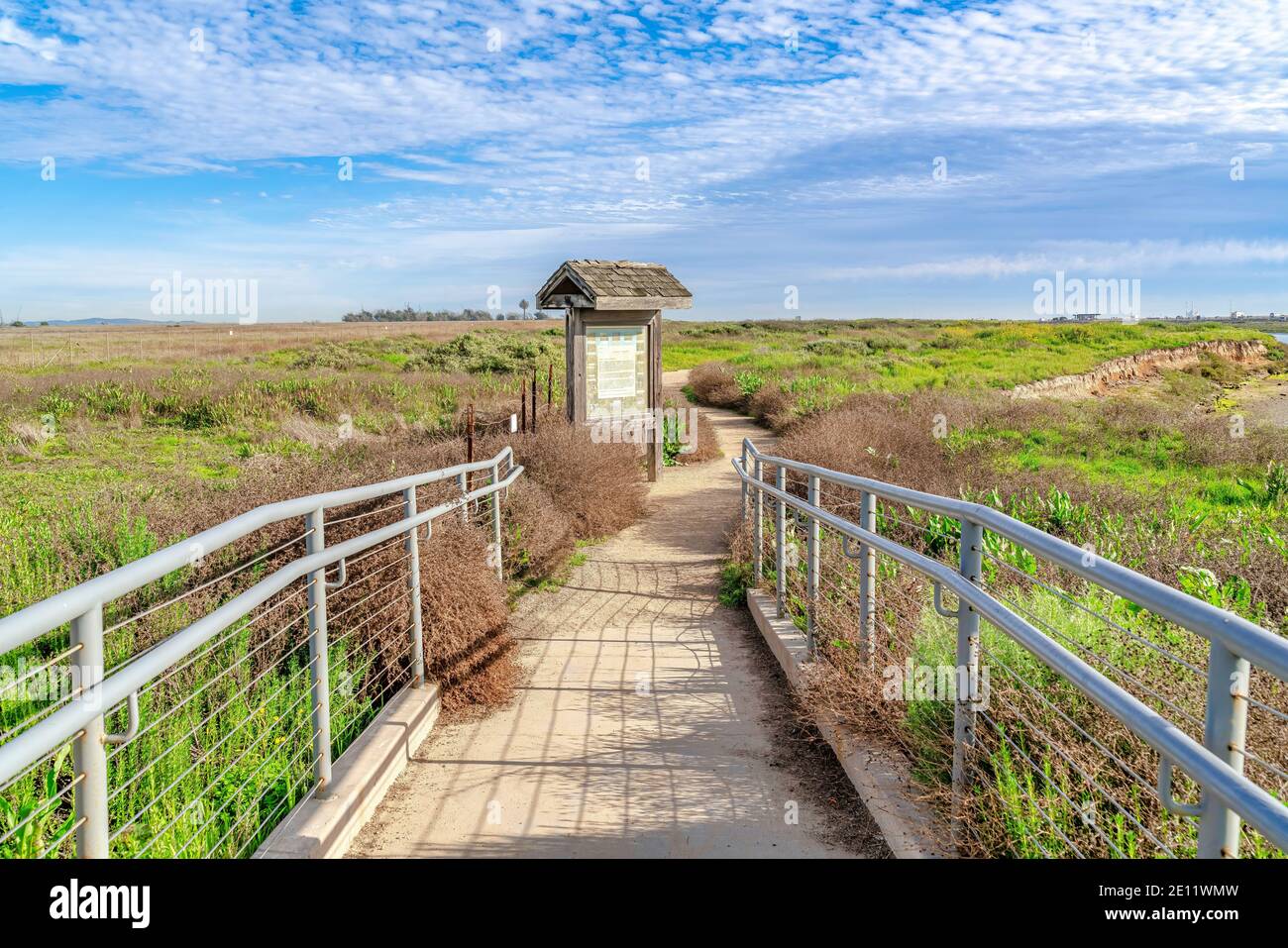 Pathway with railing and sign board with roof on grass land in ...