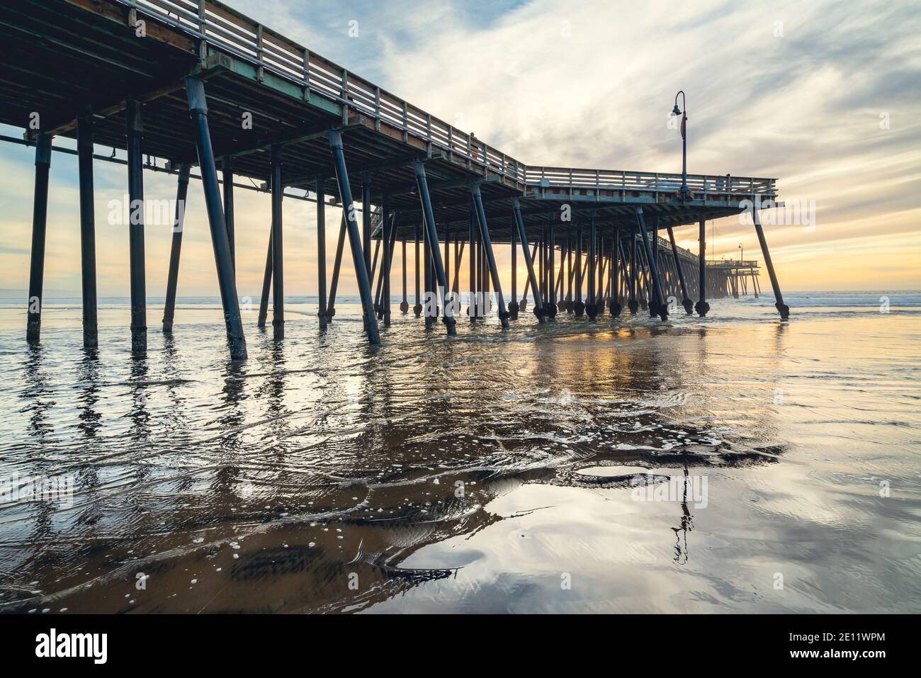 An iconic historical Pismo Beach pier that stretches toward the setting ...