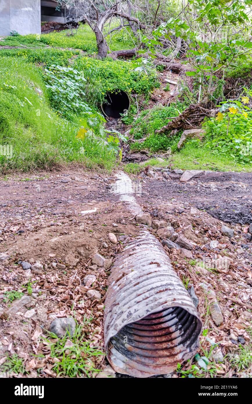 Metal drainage pipes under dry rocky soil of a slope in San Diego ...