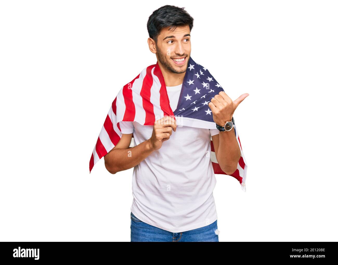 Young handsome man holding united states flag pointing thumb up to the ...