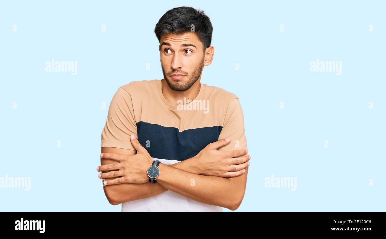 Young handsome man wearing casual clothes shaking and freezing for ...