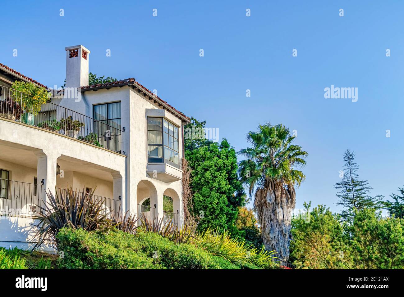 Bay window balcony and porch of house amidst plants in San Diego ...