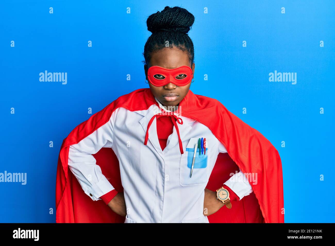 Young african american woman wearing doctor uniform and super hero ...