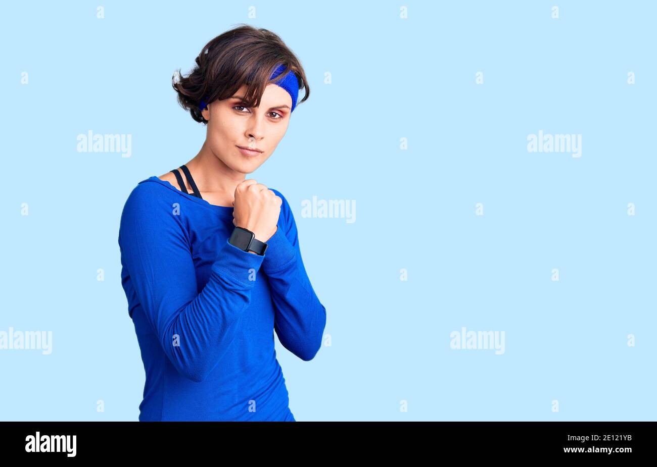 Beautiful young woman with short hair wearing training workout clothes ...