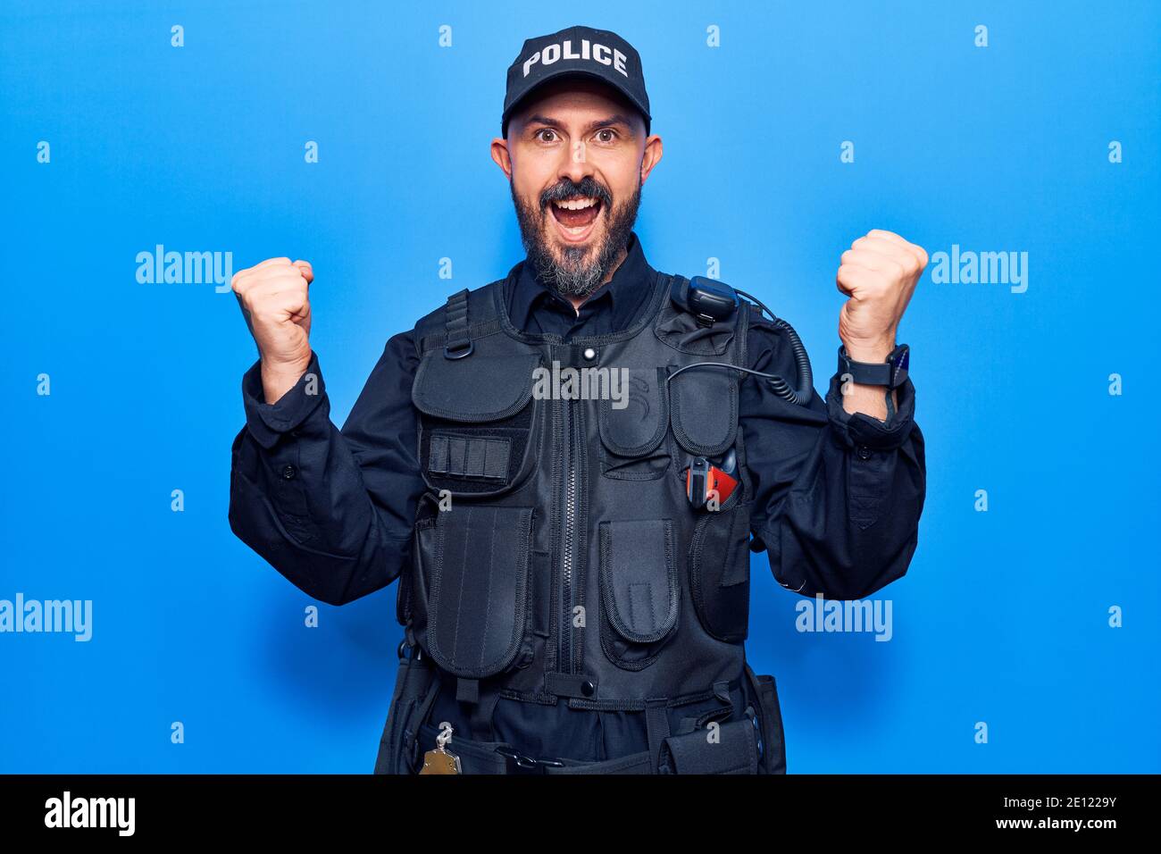 Young handsome man wearing police uniform screaming proud, celebrating ...