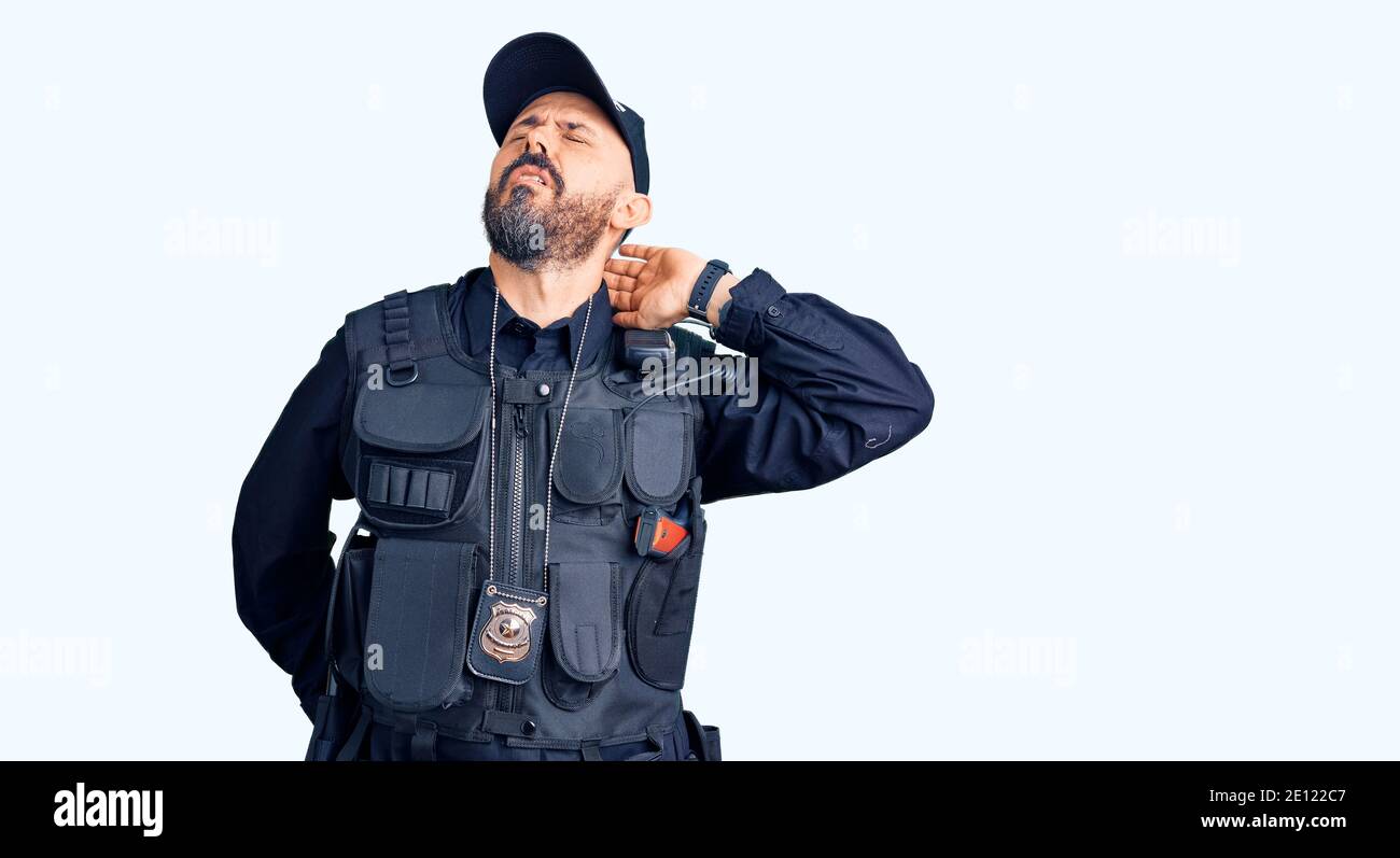 Young handsome man wearing police uniform suffering of neck ache injury ...