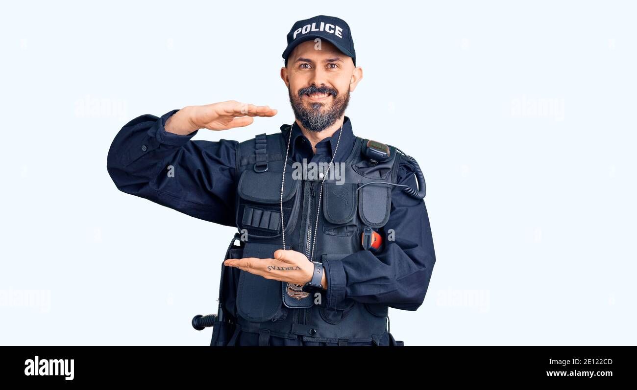 Young handsome man wearing police uniform gesturing with hands showing ...