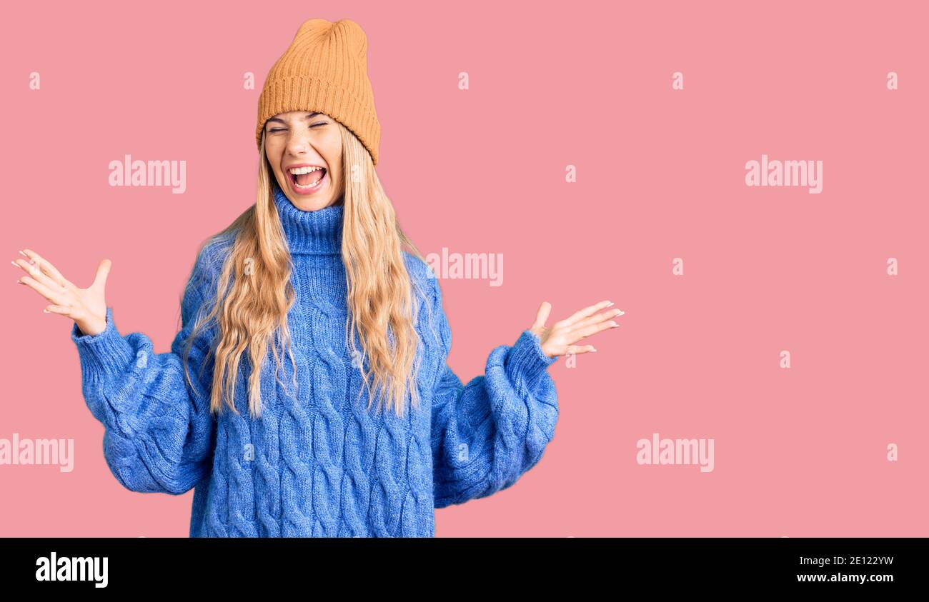 Beautiful caucasian woman with blonde hair wearing wool sweater and ...