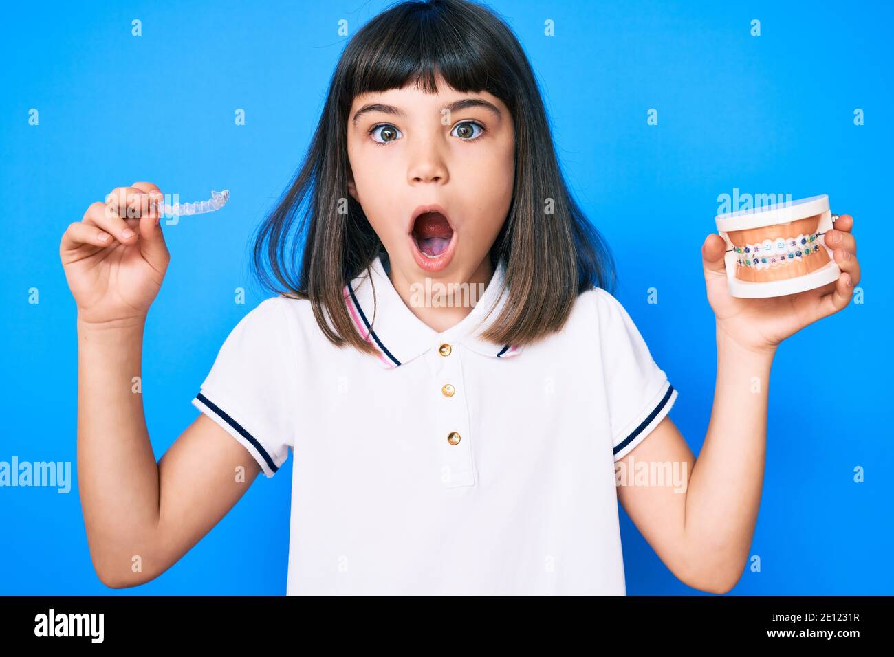Young little girl with bang holding invisible aligner orthodontic and ...