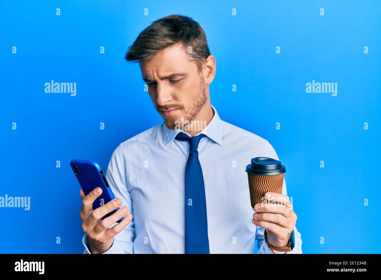 Handsome caucasian business man using smartphone and drinking a cup of ...