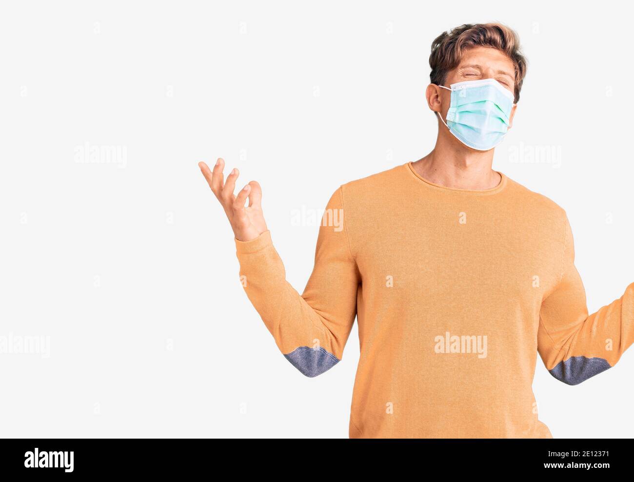 Young handsome man wearing medical mask crazy and mad shouting and ...