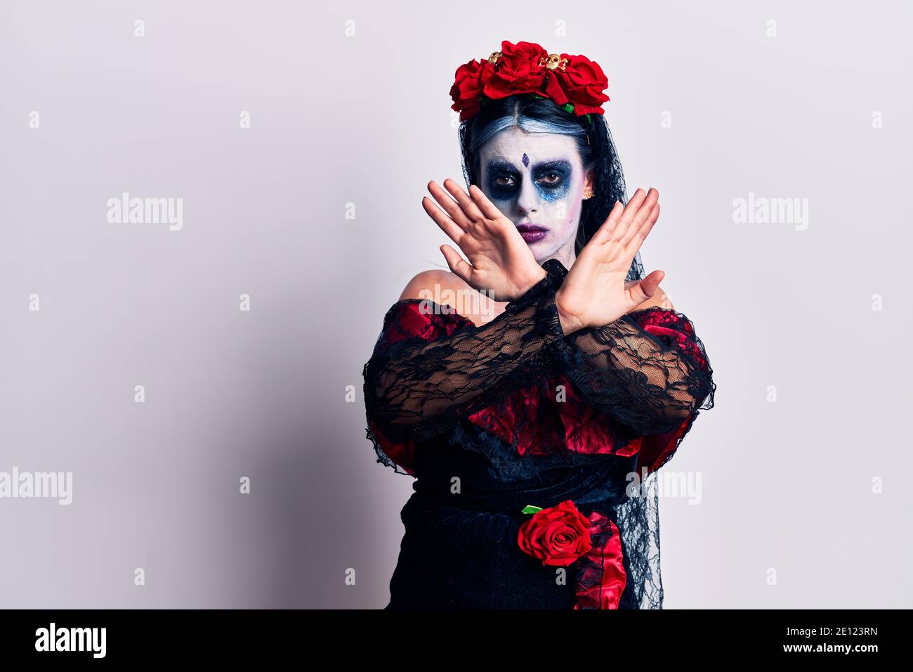 Young woman wearing mexican day of the dead makeup rejection expression ...