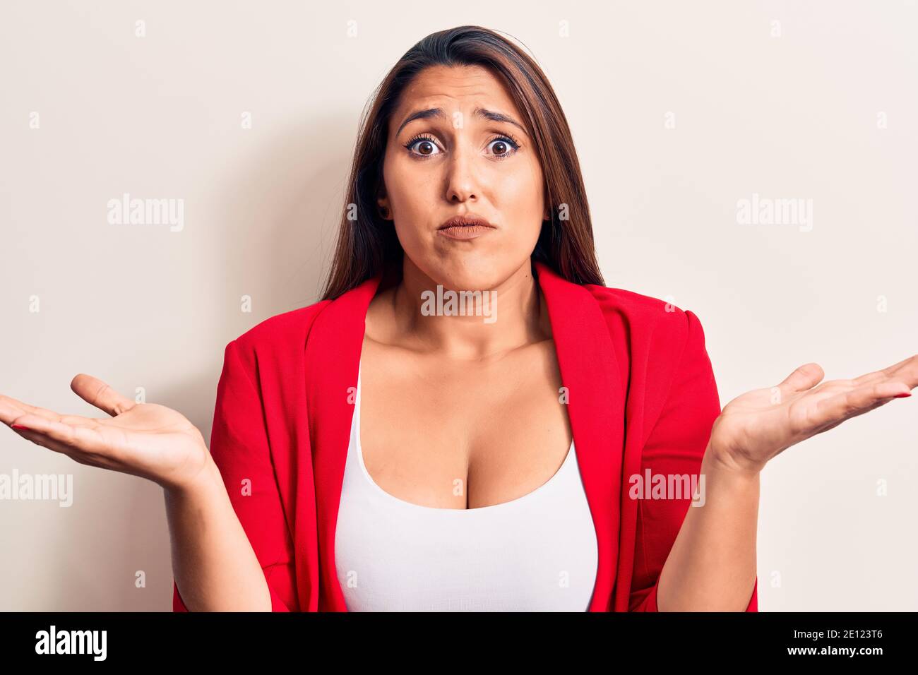 Young beautiful brunette woman wearing elegant jacket clueless and ...