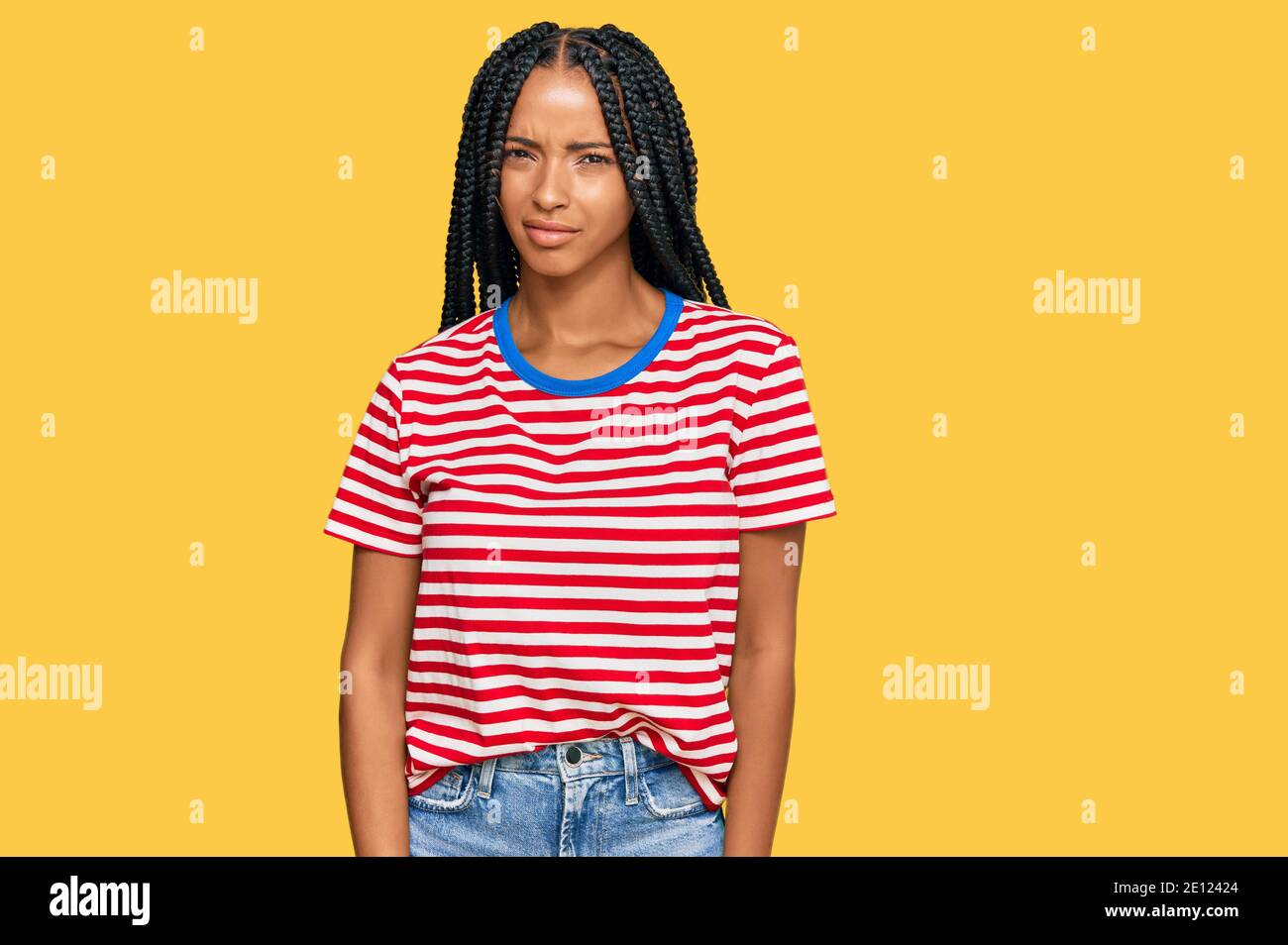 Beautiful hispanic woman wearing casual clothes in shock face, looking ...