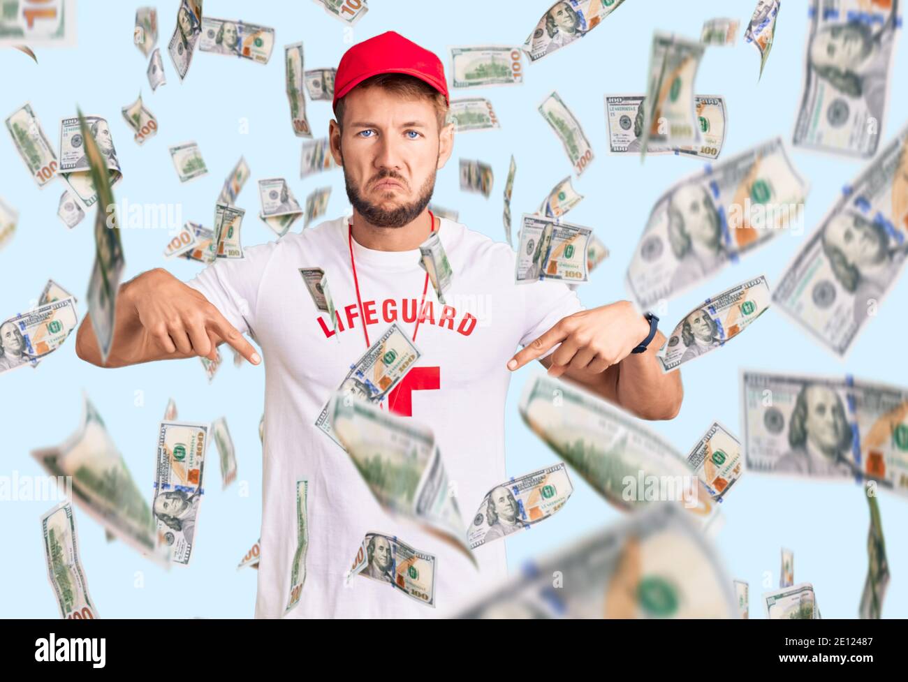 Young caucasian man wearing lifeguard t shirt holding whistle pointing ...