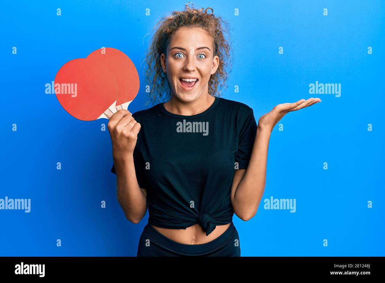 Beautiful caucasian teenager girl holding red ping pong rackets ...