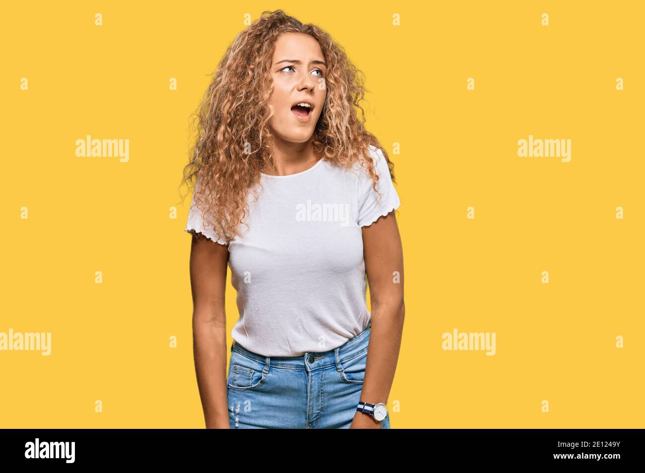 Beautiful caucasian teenager girl wearing casual white tshirt angry and ...