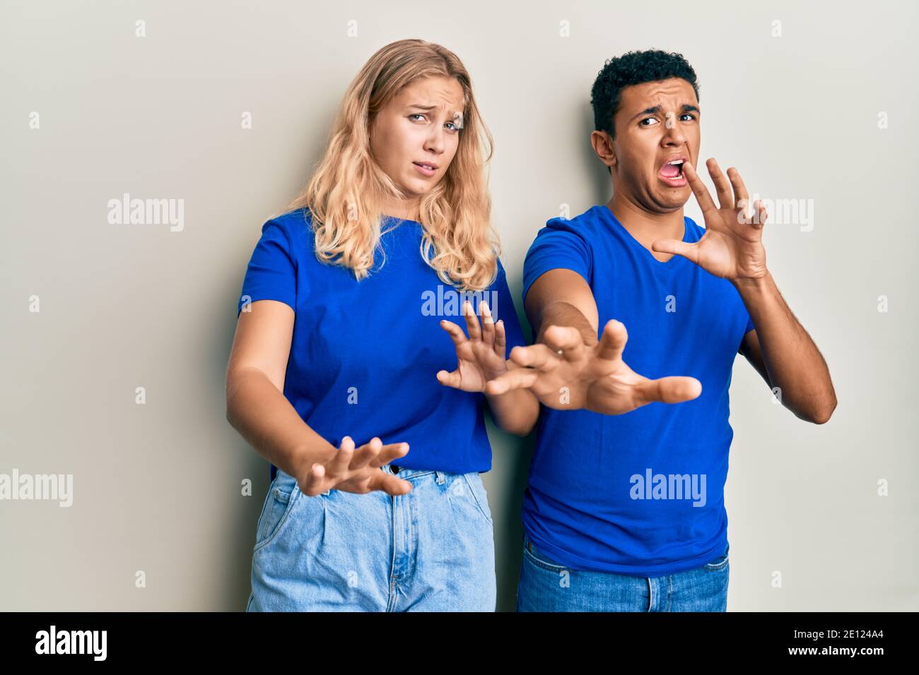 Young interracial couple wearing casual clothes afraid and terrified ...