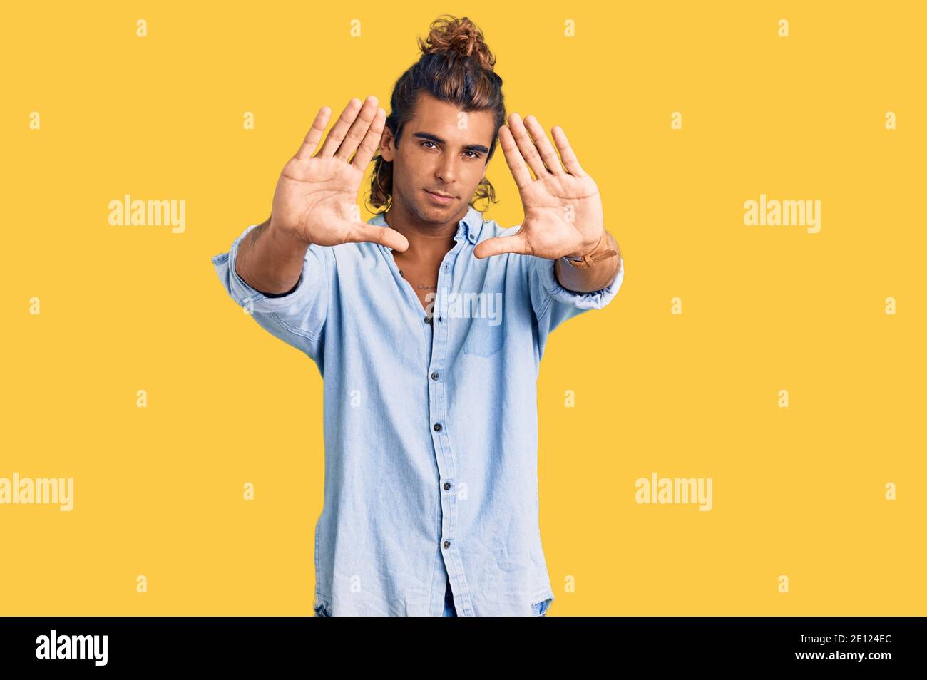 Young hispanic man wearing summer style doing frame using hands palms ...