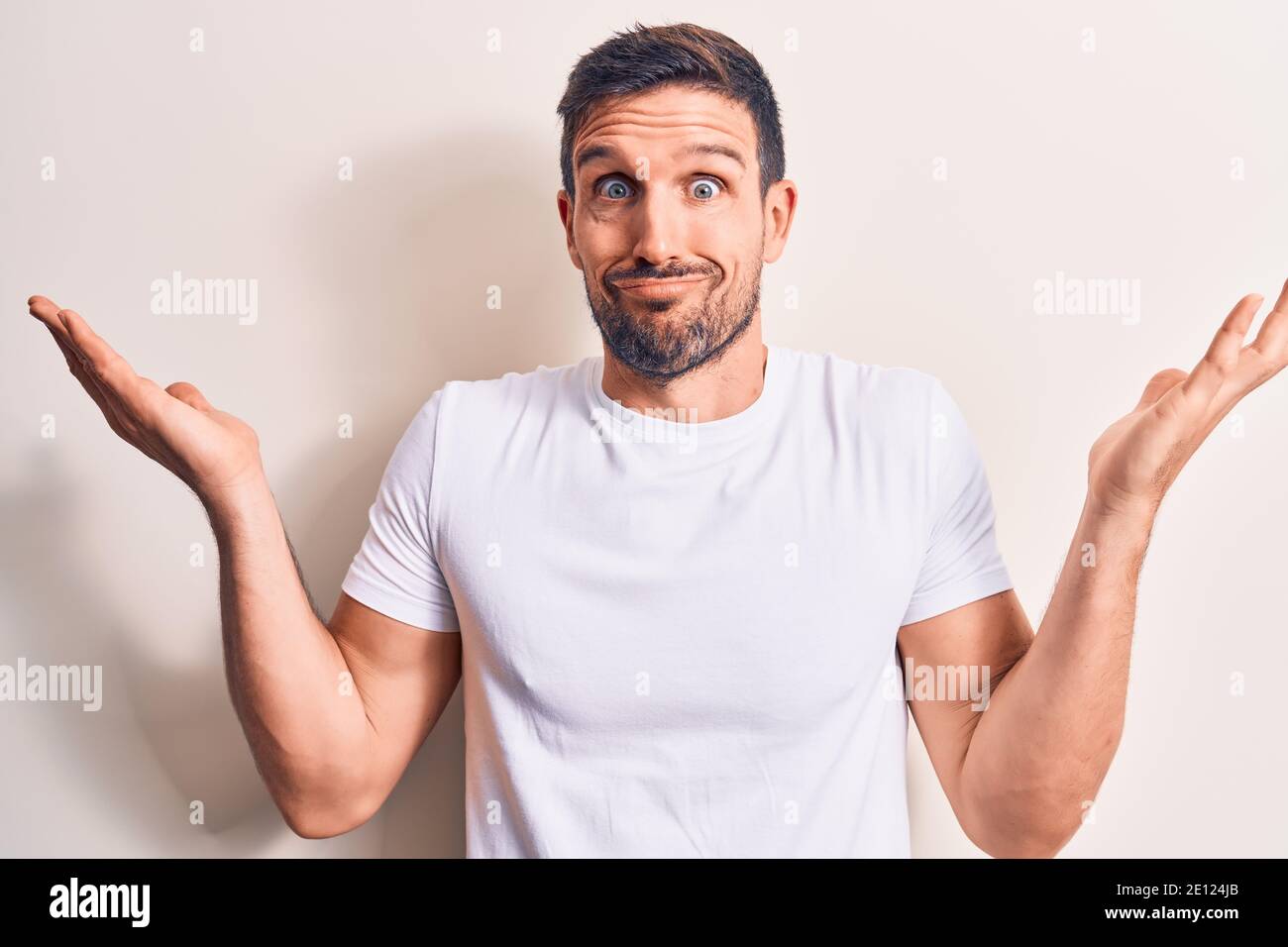 Young handsome man wearing casual t-shirt standing over isolated white ...