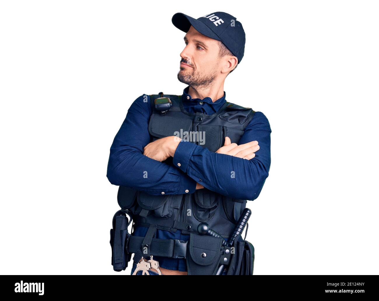Young handsome man wearing police uniform looking to the side with arms ...