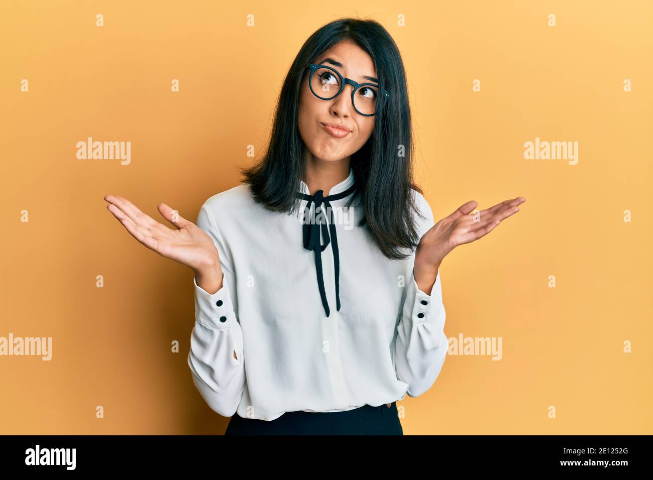 Beautiful asian young woman wearing business shirt clueless and ...