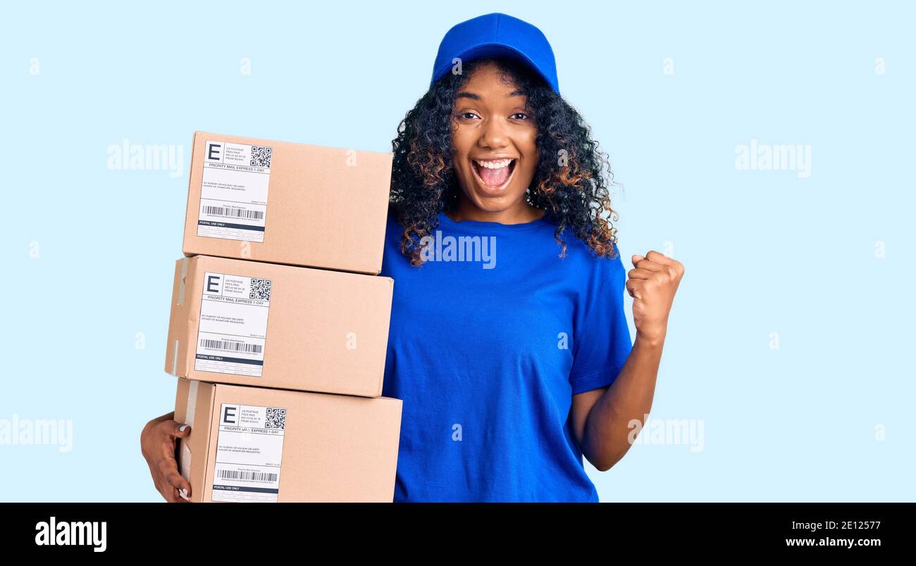 Young african american woman holding delivery package screaming proud ...