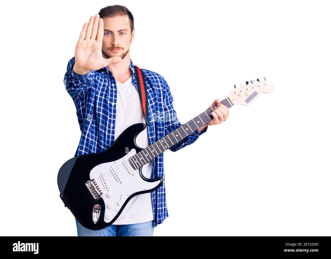 Young handsome caucasian man playing electric guitar with open hand ...