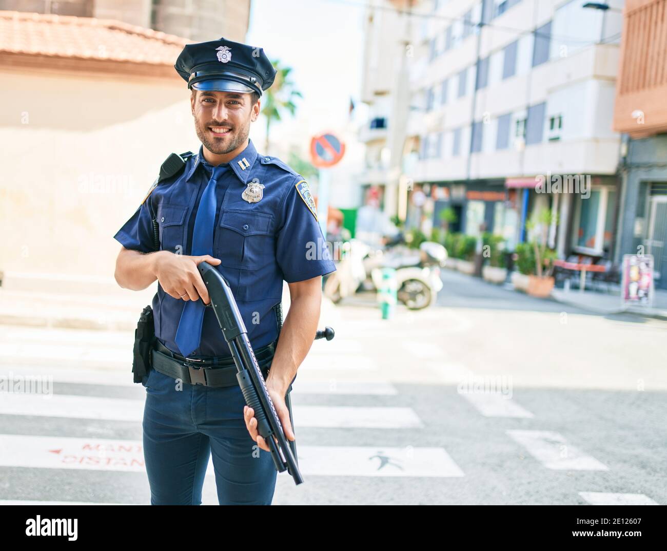 Young handsome hispanic policeman wearing police uniform smiling happy ...