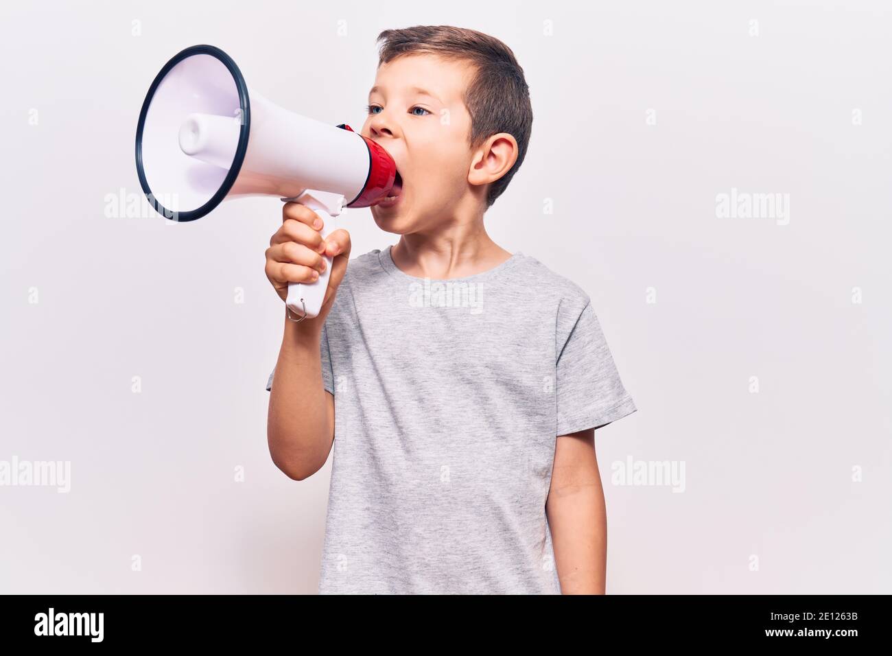 Adorable caucasian kid boy with angry expression. Screaming loud using ...