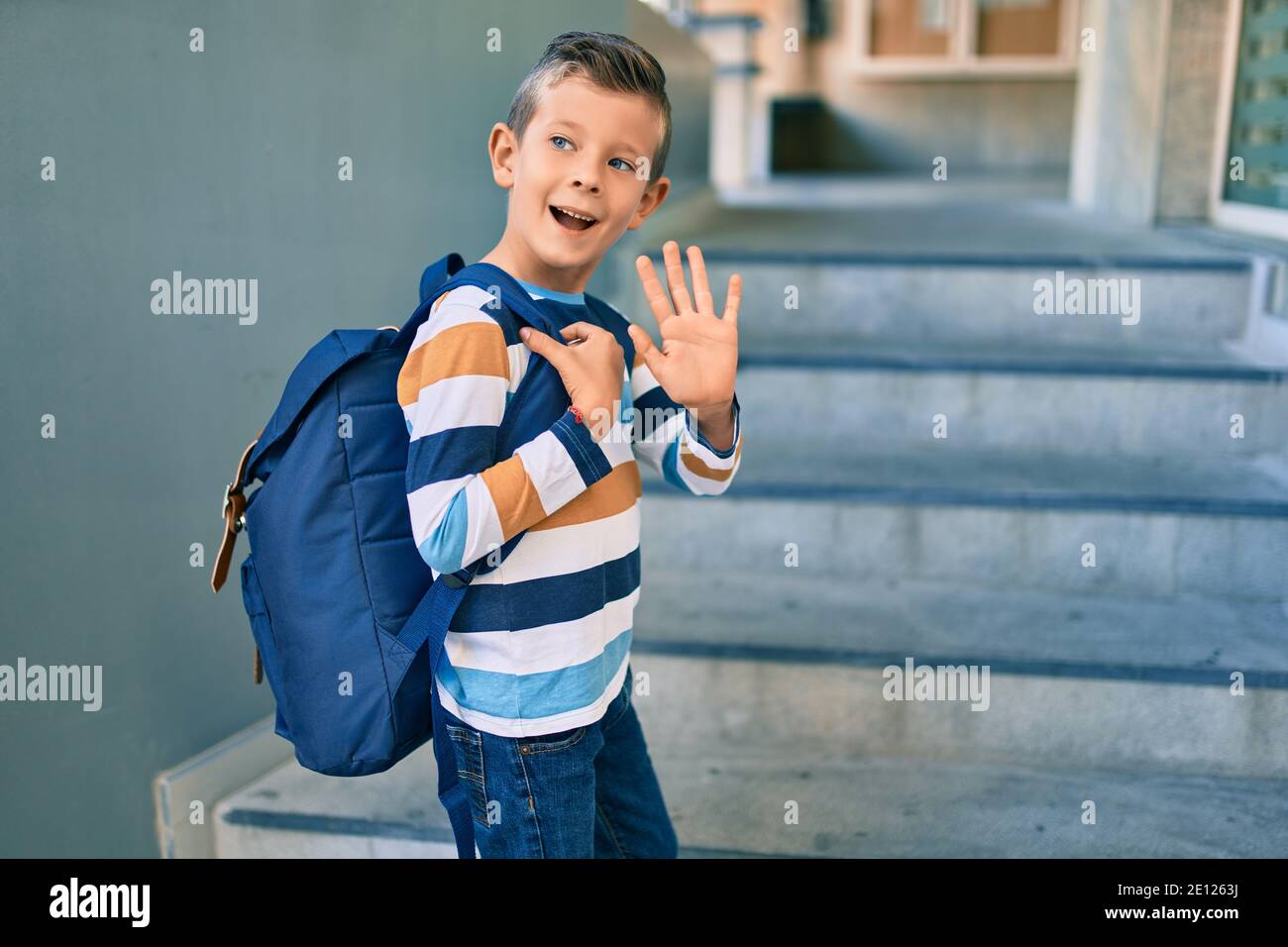 Adorable caucasian student boy smiling happy saying goodbye at the ...