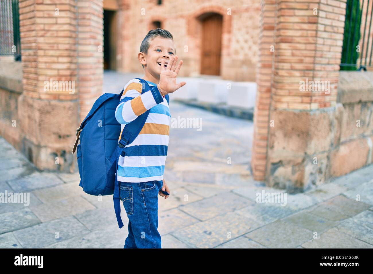 Adorable caucasian student boy smiling happy saying goodbye with hand ...