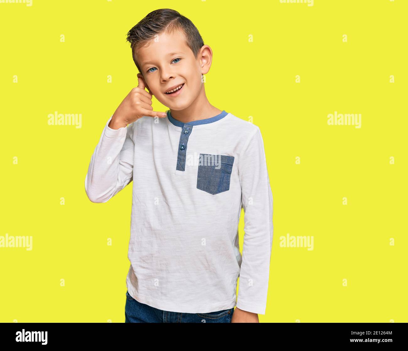 Adorable caucasian kid wearing casual clothes smiling doing phone ...