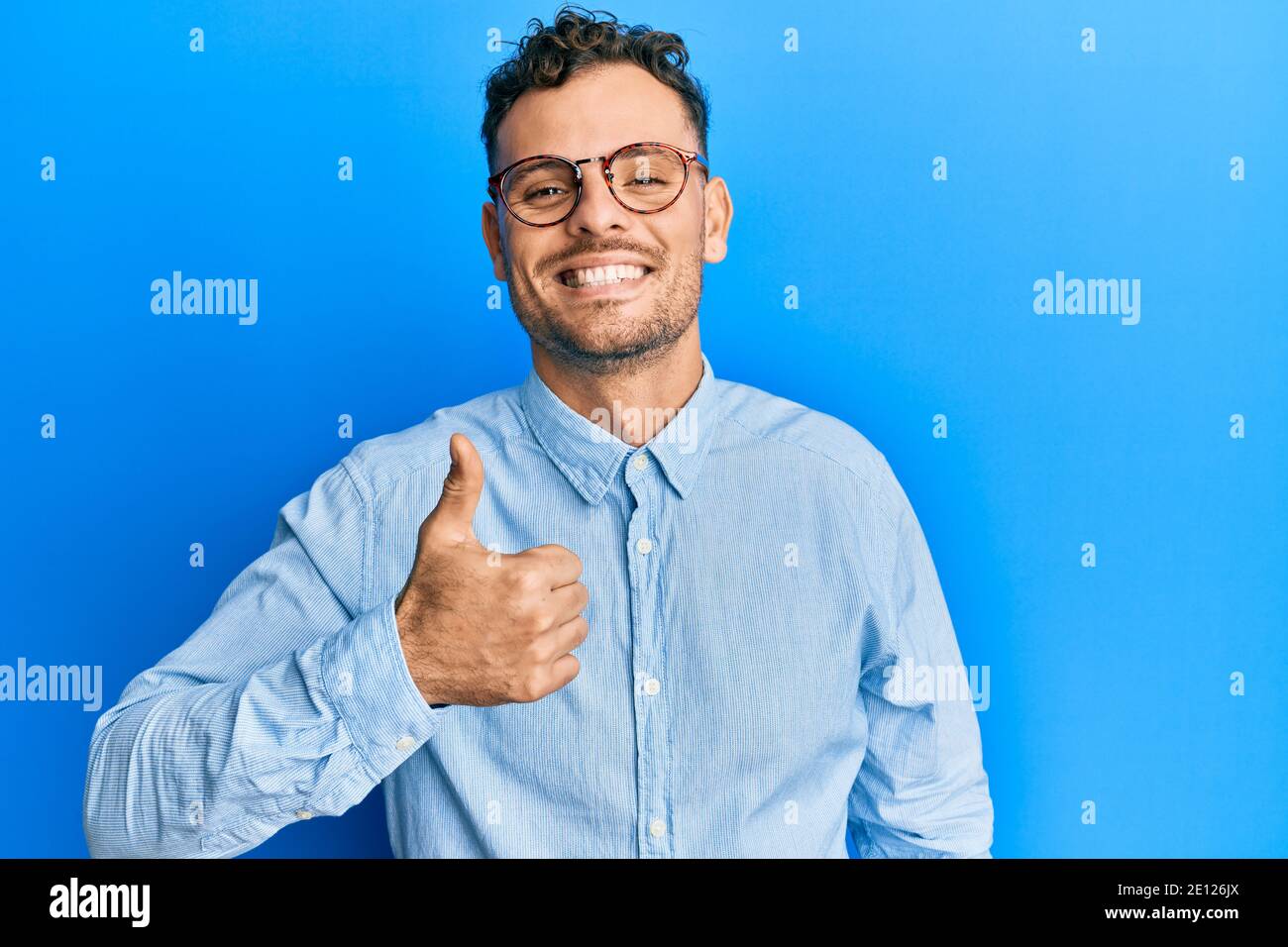 Young hispanic man wearing casual clothes and glasses doing happy ...