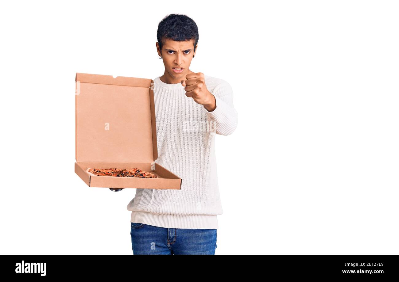 Young african amercian man holding delivery pizza box annoyed and ...