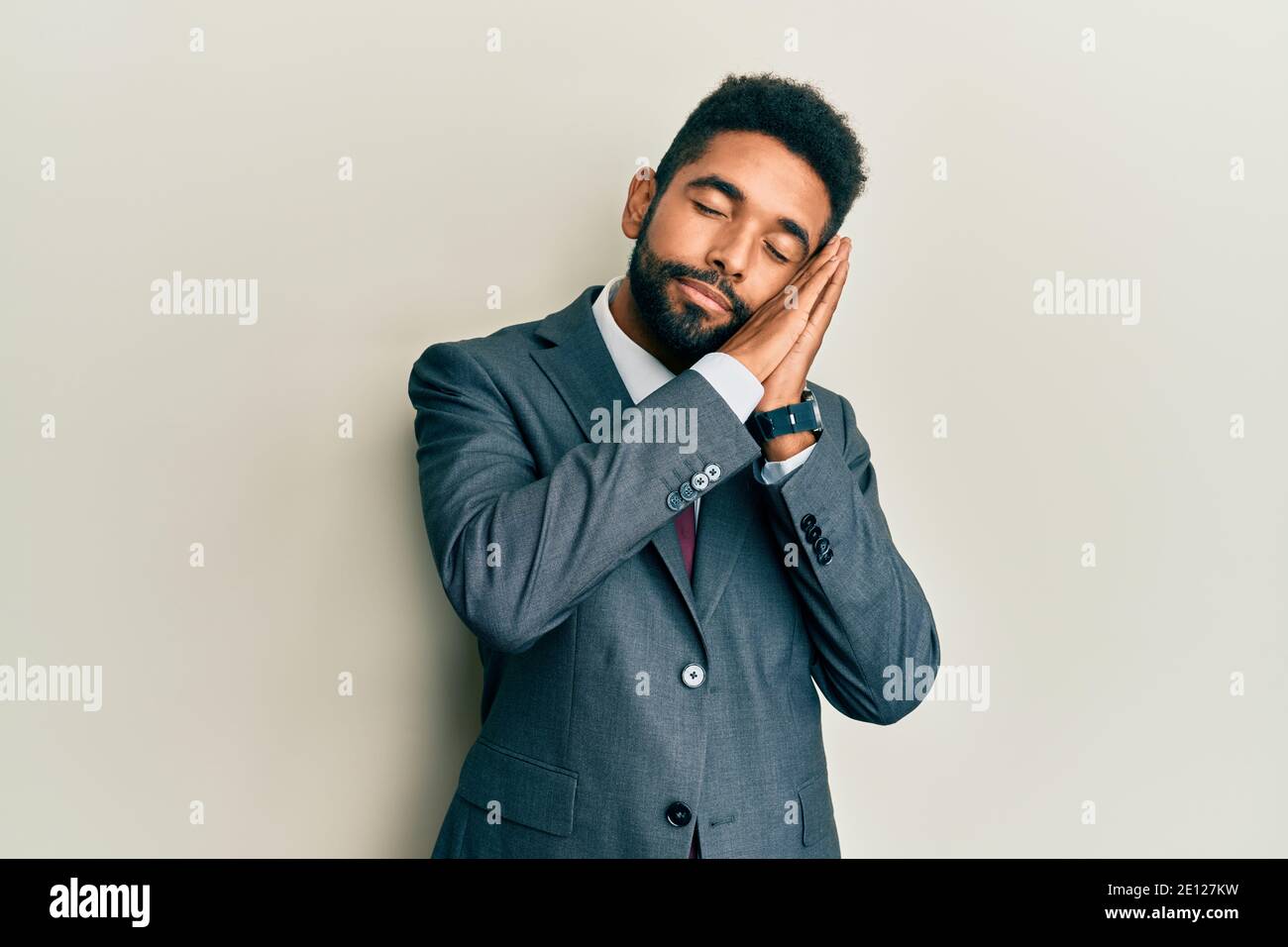 Handsome hispanic man with beard wearing business suit and tie sleeping ...