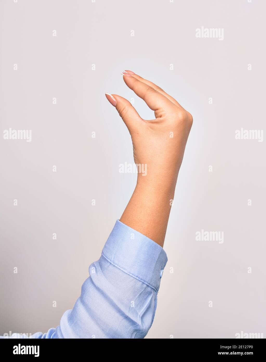 Hand of caucasian young woman doing catch sign over isolated white ...