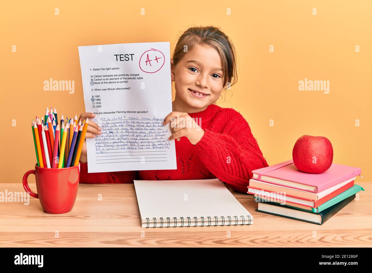 Little beautiful girl showing a passed exam looking positive and happy ...
